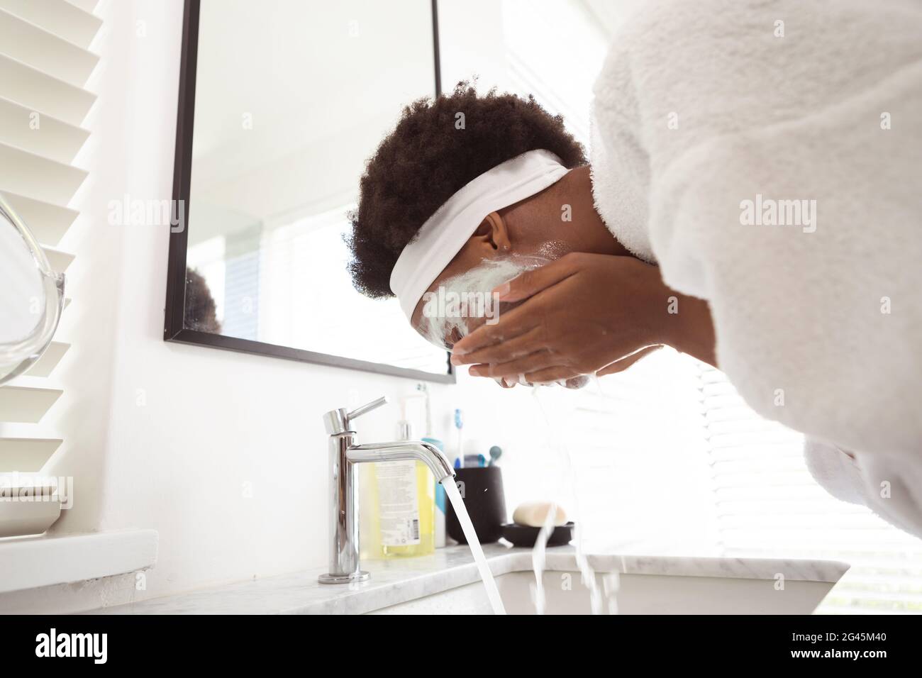 Woman washing her face in the bathroom sink Stock Photo - Alamy