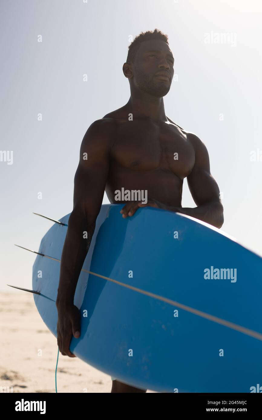 African American man holding surf board on the beach Stock Photo - Alamy