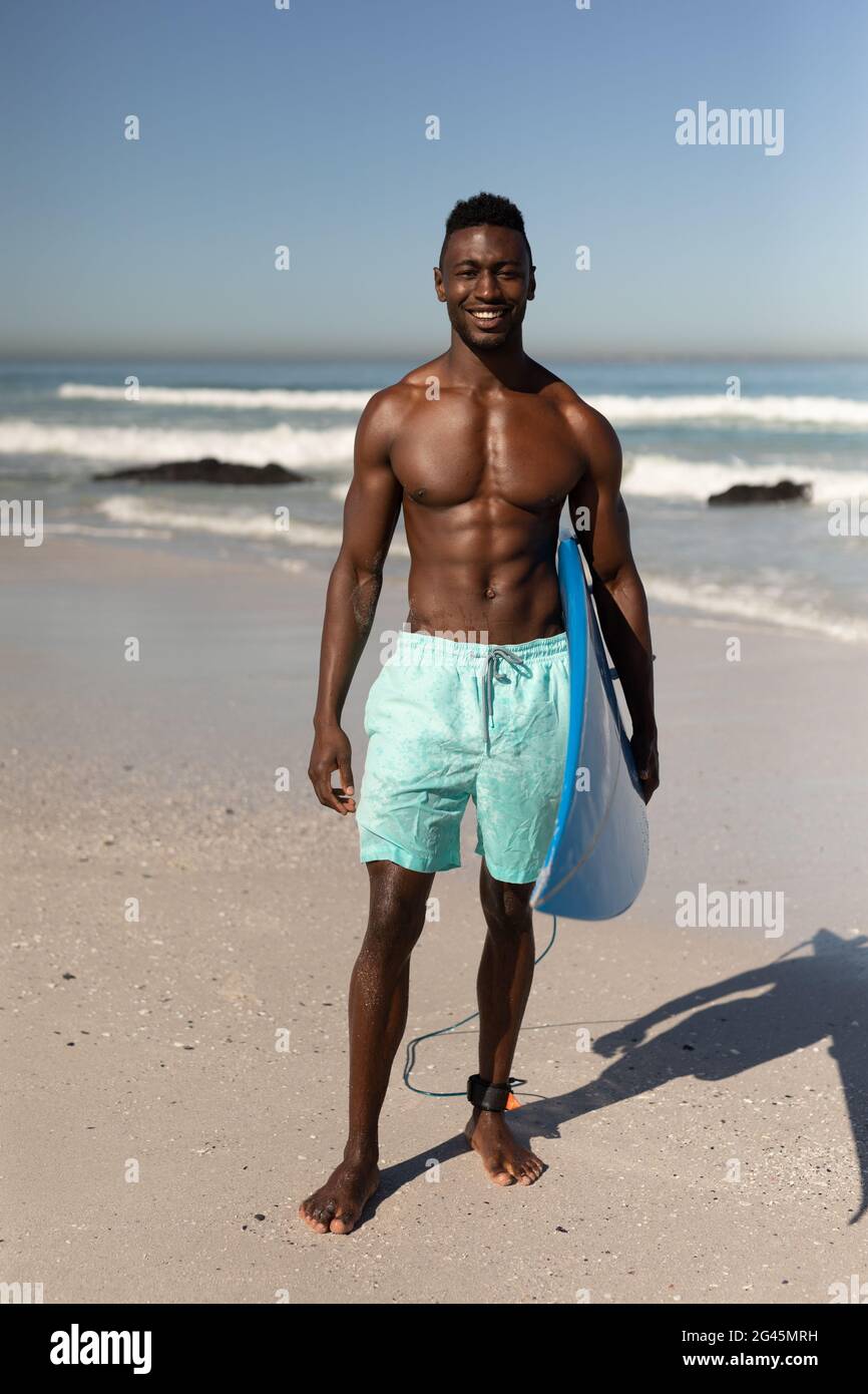 African American man holding surf board on the beach Stock Photo - Alamy