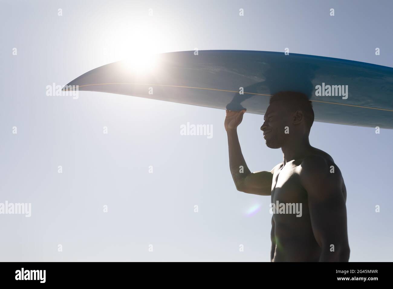 African American man holding surf board on the beach Stock Photo - Alamy