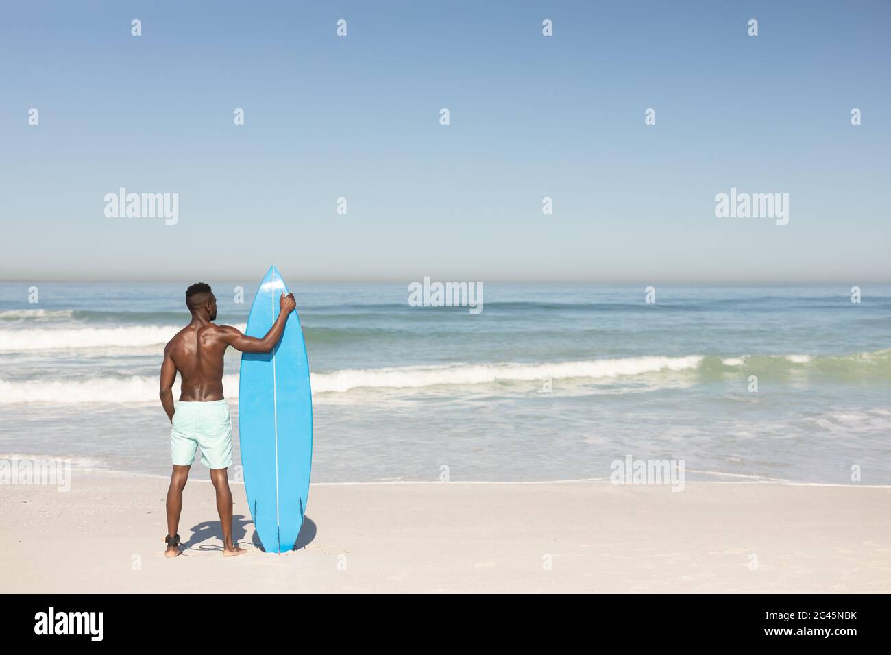 African American man holding surf board on the beach Stock Photo - Alamy