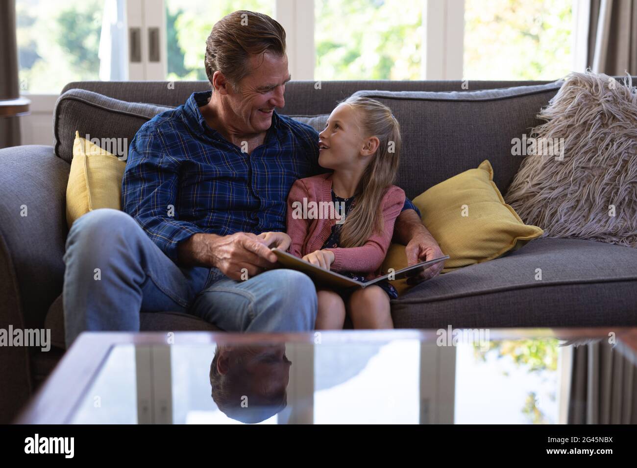 Caucasian girl and her grandfather spending time together at home ...
