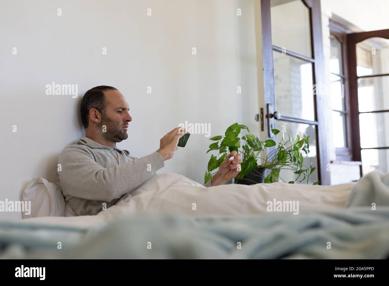Sick Caucasian man self isolating and social distancing in quarantine ...