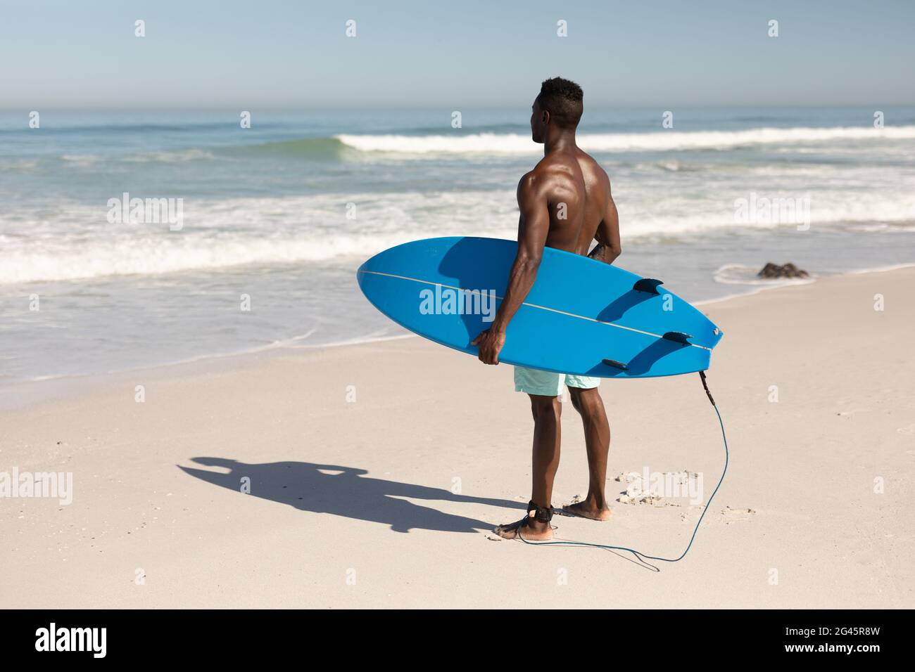 African American man holding surf board on the beach Stock Photo - Alamy