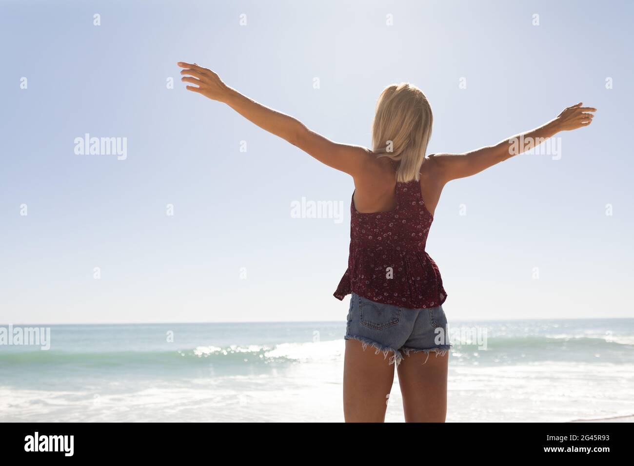 Young caucasian woman raising arms on the beach Stock Photo - Alamy