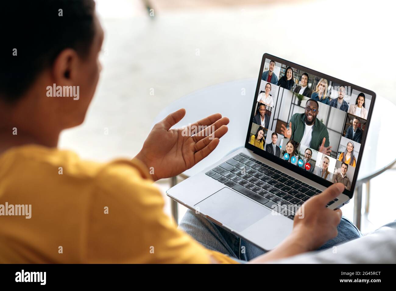 Distant communication using app and laptop. The guy sits on the couch ...