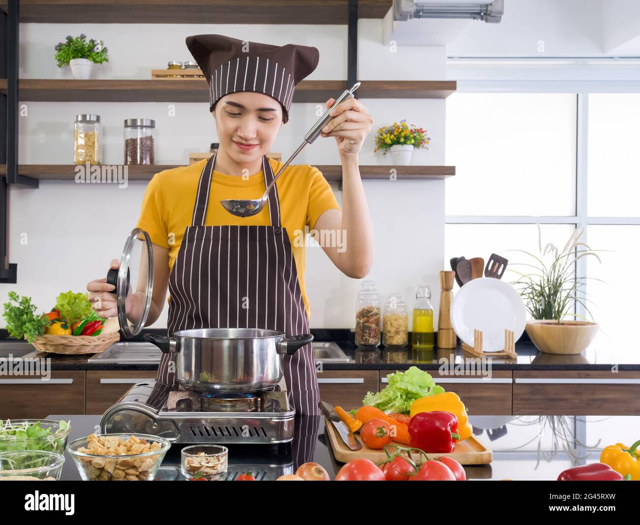 The maid is doing the meat stew in a modern kitchen Stock Photo - Alamy