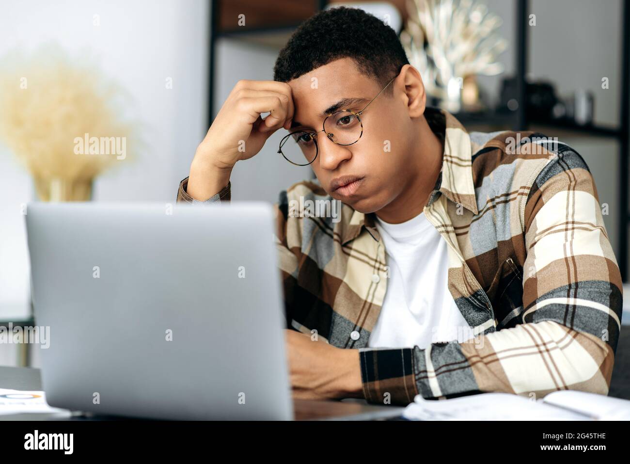 Upset frustrated hispanic guy, office worker or freelancer, sits at ...