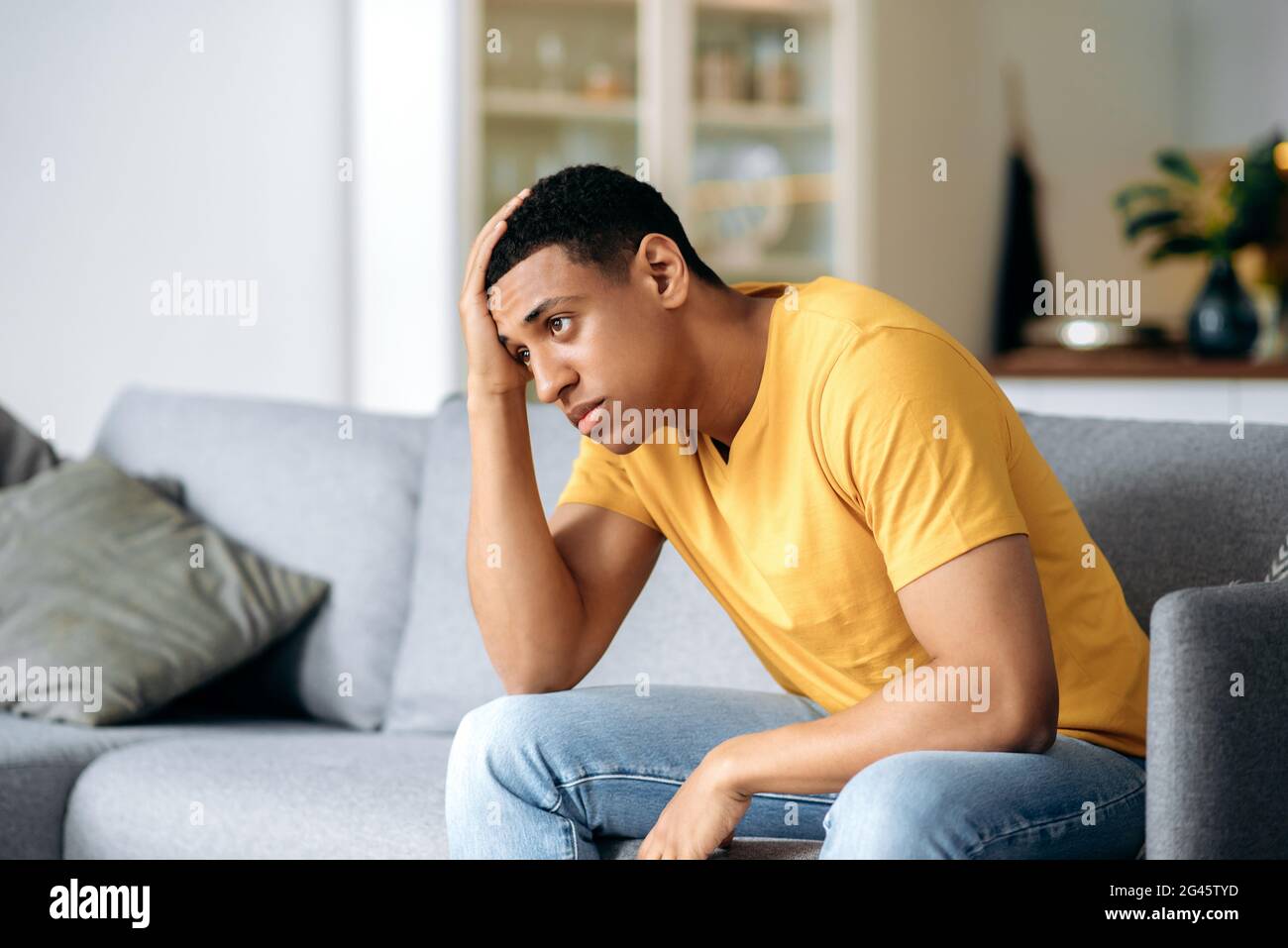 Sad unhappy handsome hispanic young adult alone man, sitting on the ...