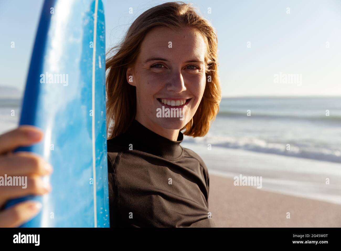 Portrait of smiling woman with surfboard at the beach Stock Photo - Alamy