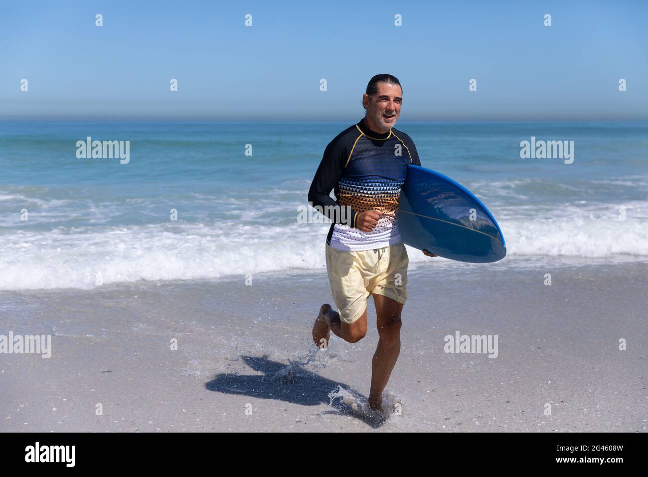 Senior Caucasian man holding a surfboard at the beach Stock Photo - Alamy