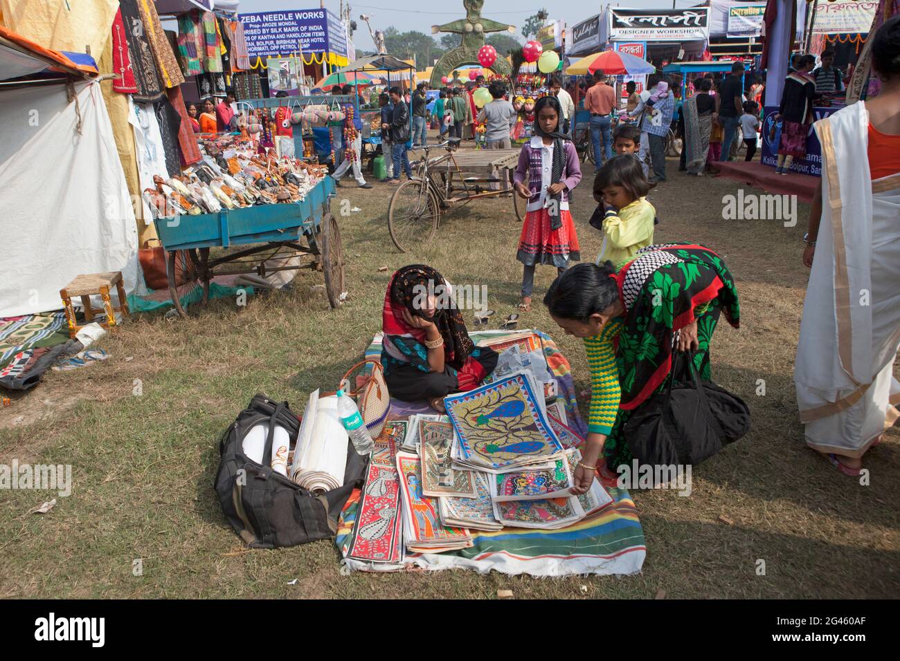 A lady drawing and selling traditional scroll painting in Poush mela, a ...