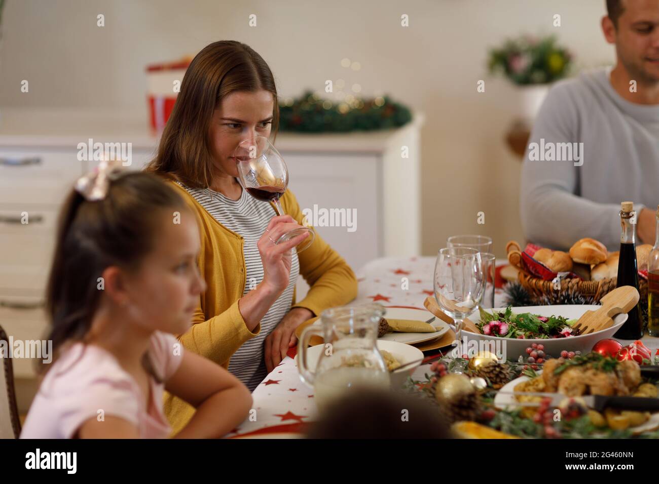 Multi generation caucasian family sitting at table and holding glass of ...