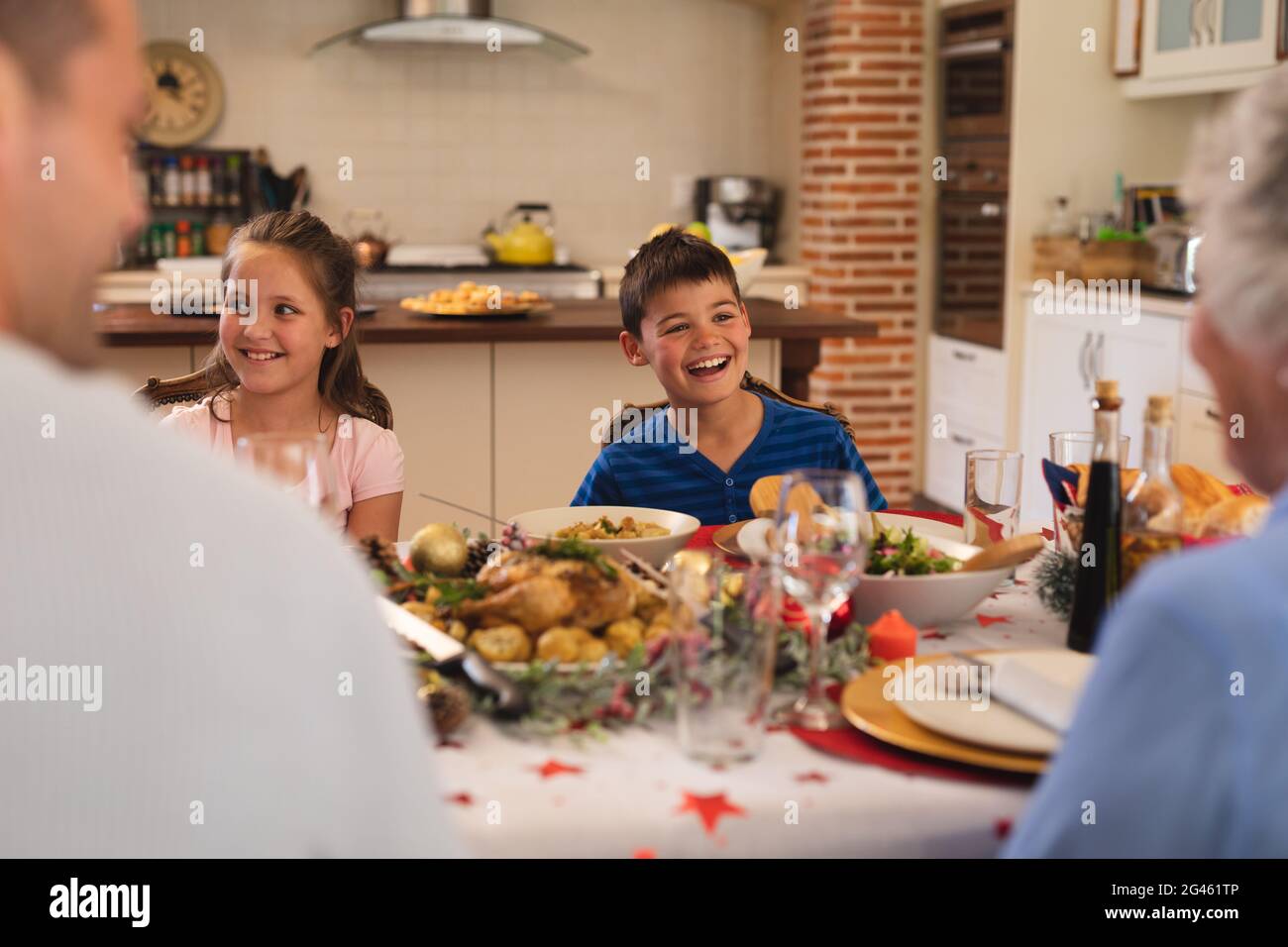 Multi generation caucasian family sitting at table for dinner together ...