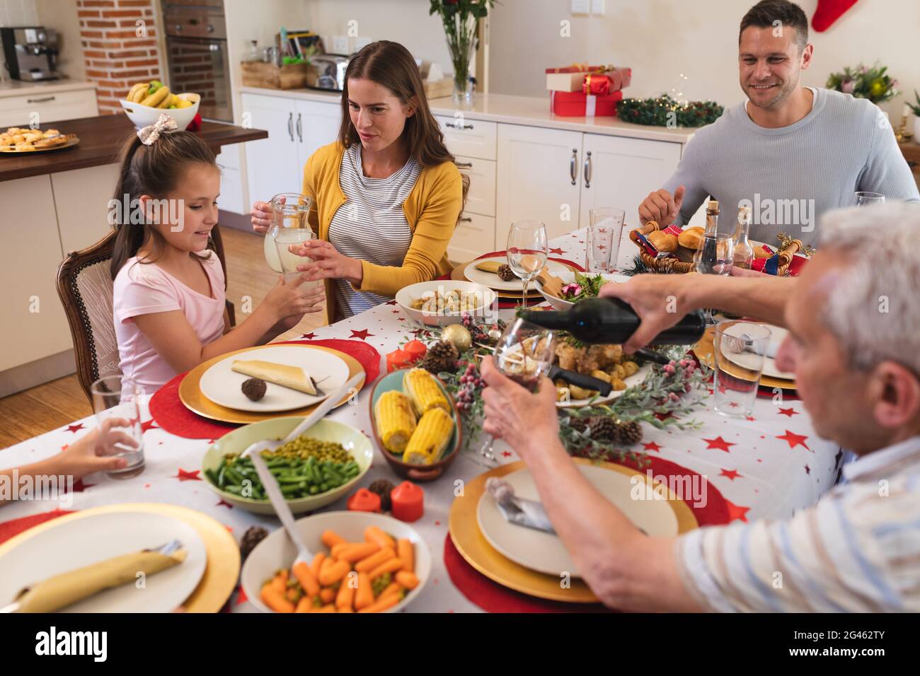 Multi generation caucasian family sitting at table for dinner together ...