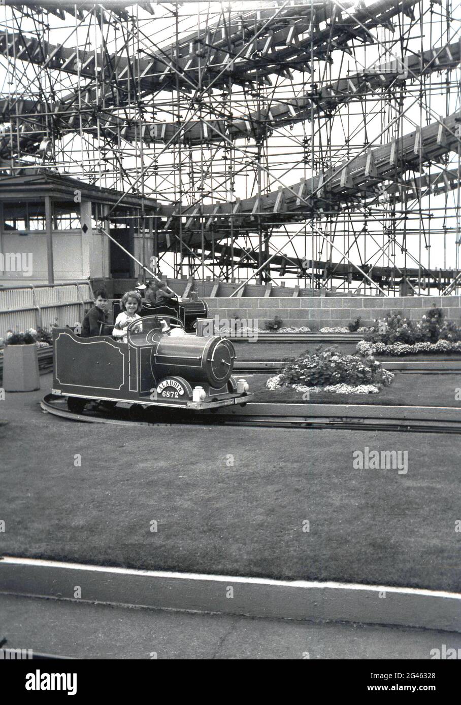 1962, historical two young children on a funfair train ride at Clacton ...
