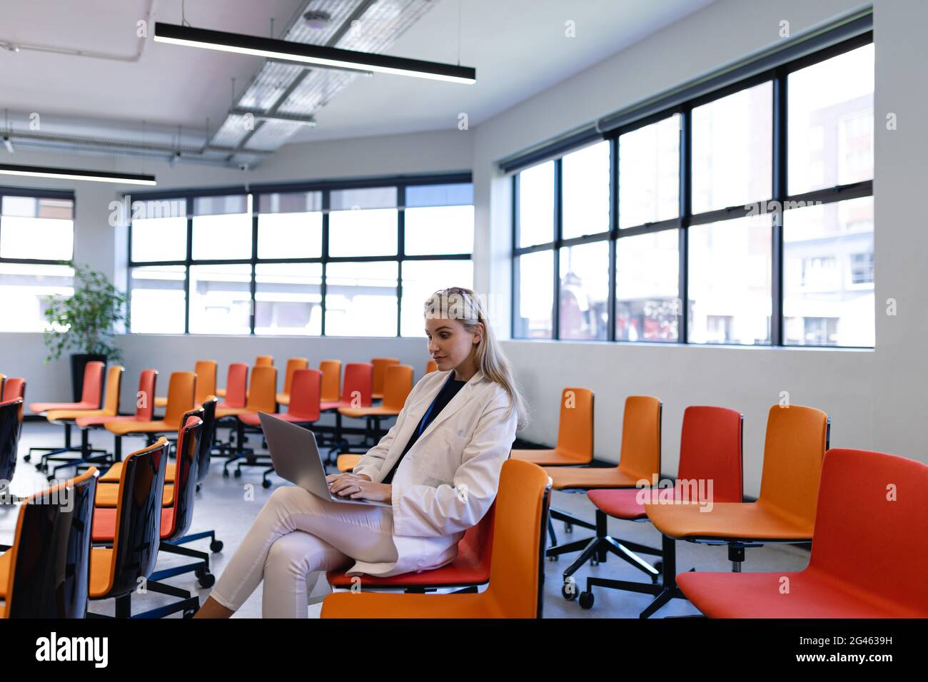 Caucasian woman in a conference room on her laptop Stock Photo - Alamy