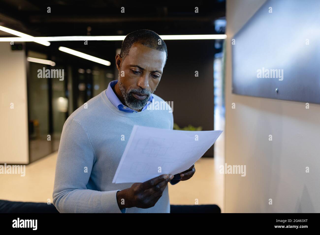 African American man reading papers in office Stock Photo - Alamy