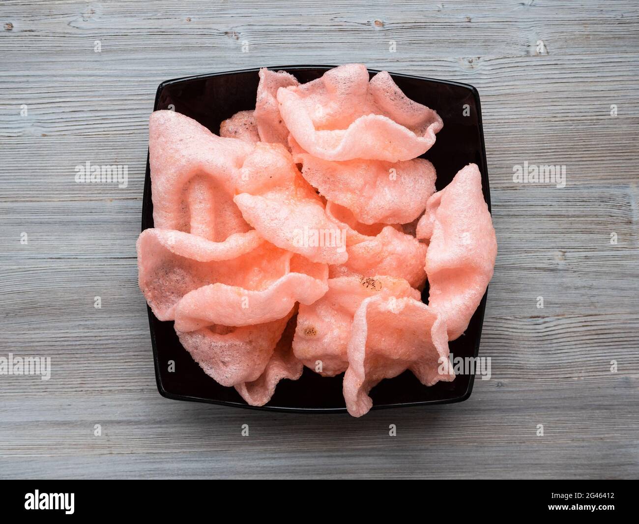 chinese cuisine - top view of shrimp chips in black bowl on wooden ...