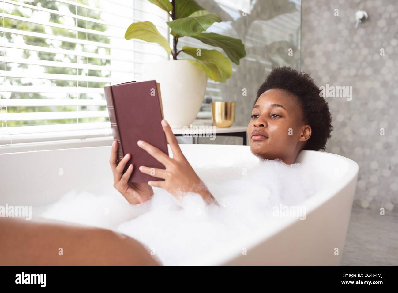 Woman reading book in a bathtub Stock Photo - Alamy