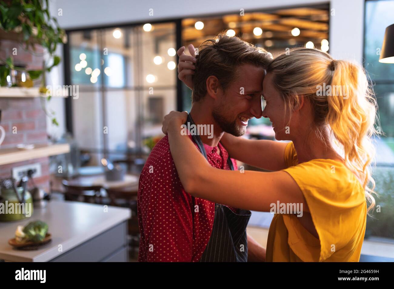 Caucasian couple spending time in the kitchen and cuddling Stock Photo ...