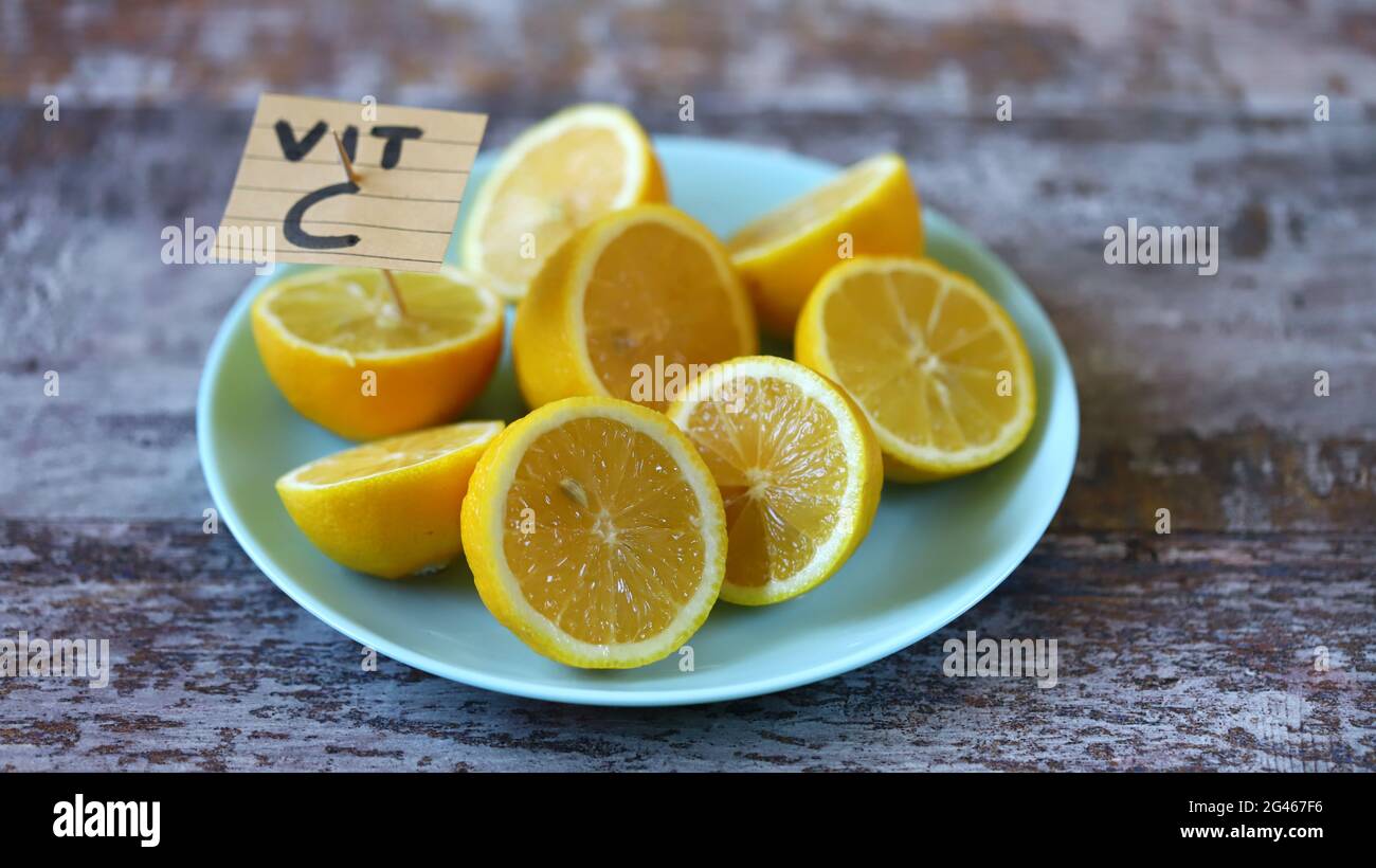 Note with the inscription Vit C in a plate with lemons. Lemons as a ...