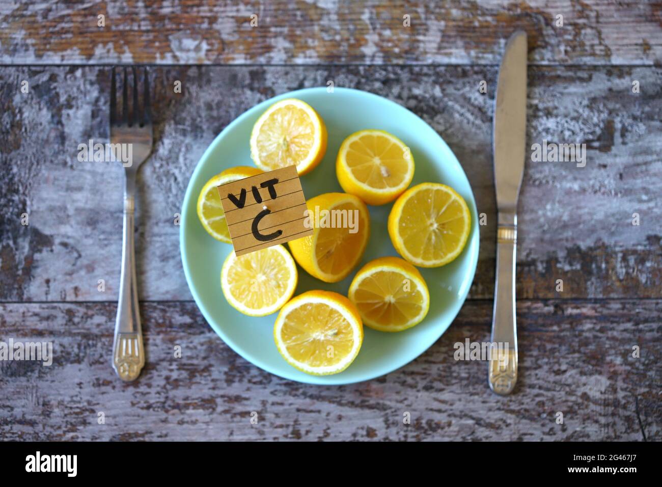 Note with the inscription Vit C in a plate with lemons. Lemons as a ...