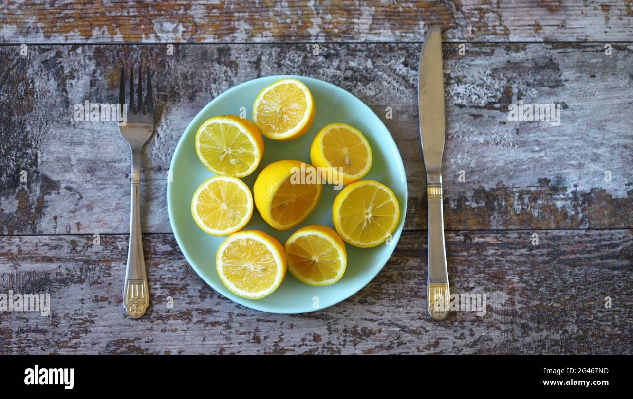 Plate with fresh lemons. Halved lemons on a plate. Vitamins concept ...