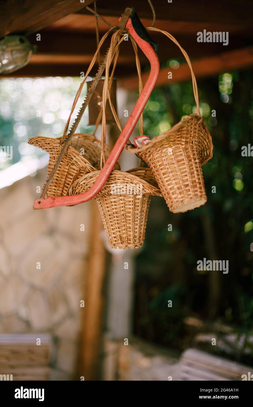 Three wicker baskets and a red saw hang under the ceiling Stock Photo ...