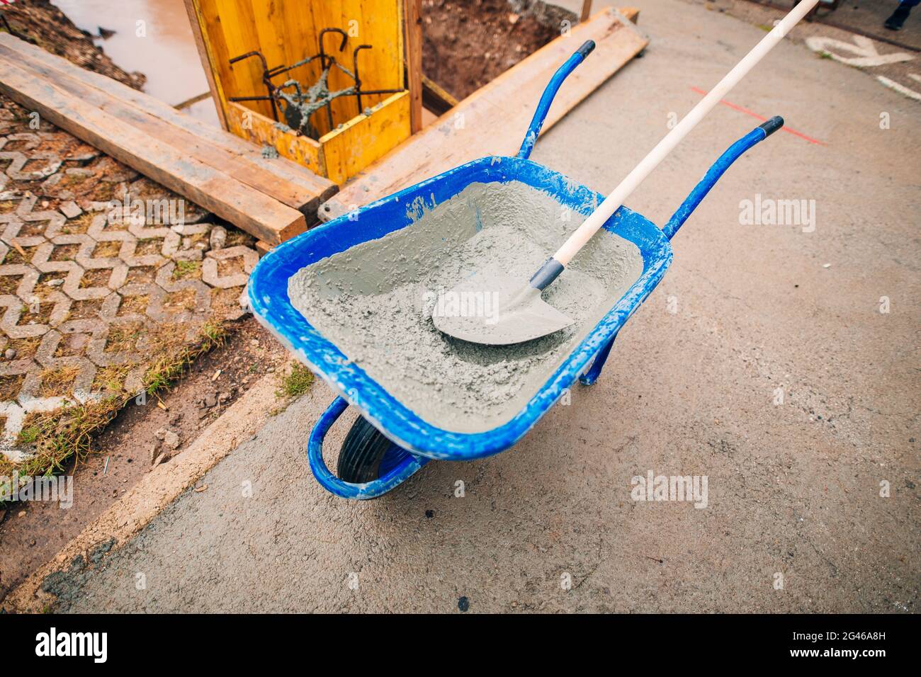 Blue clean new wheelbarrow for cement. Laying the first shovel c Stock ...