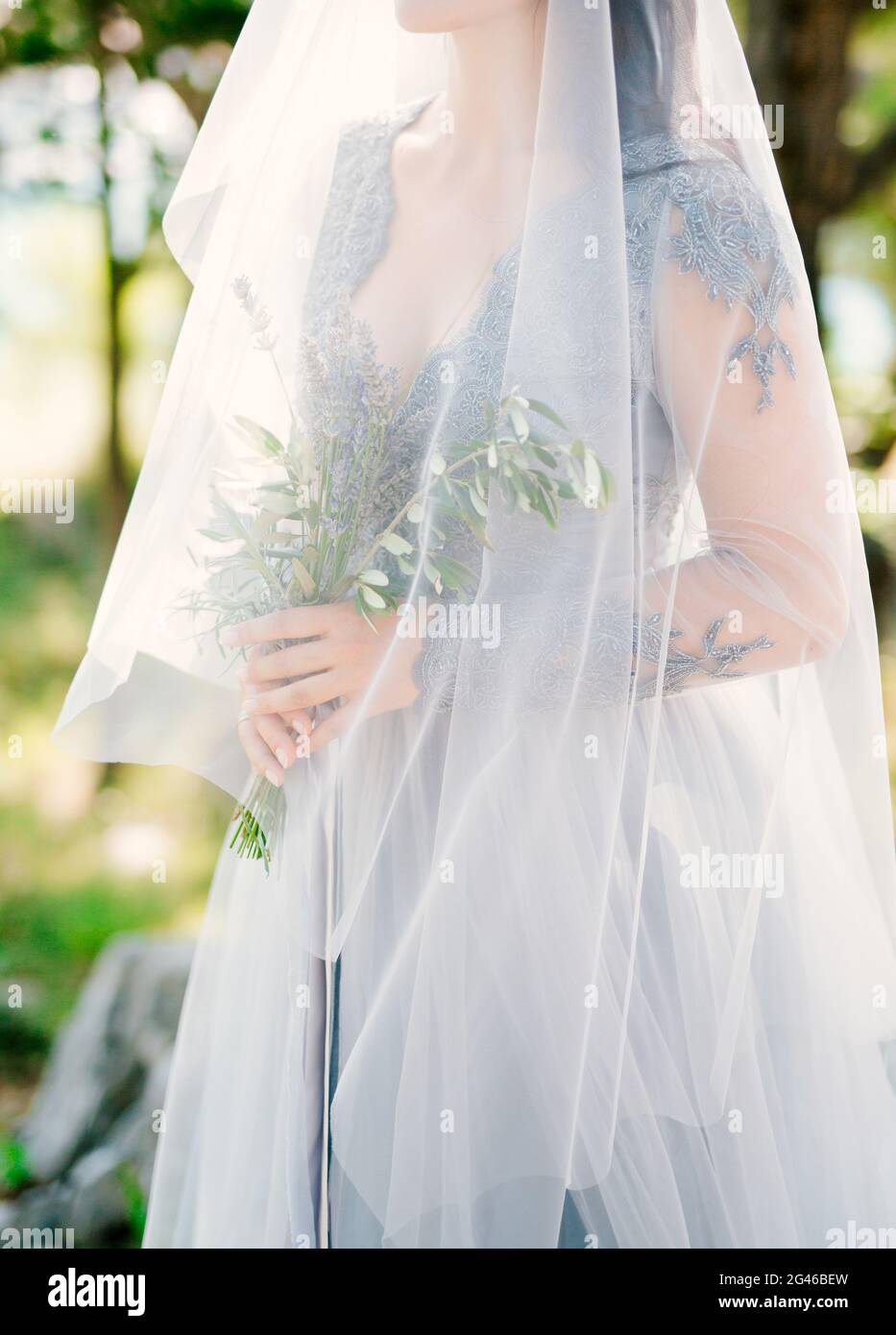 Lavender Wedding bouquet in hands of the bride under veil in pal Stock ...