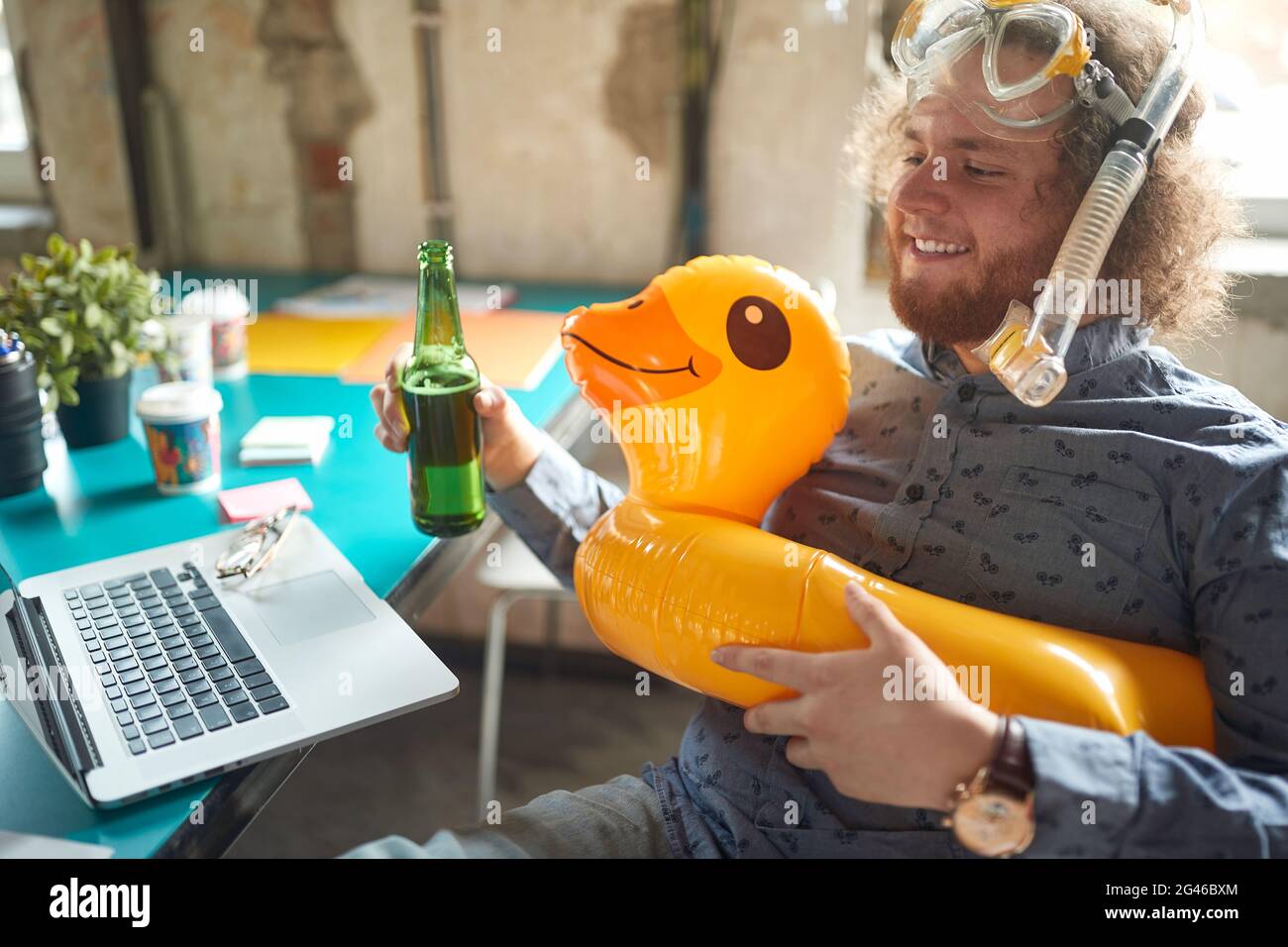 A young male office worker sitting in a relaxed atmopshere on the ...