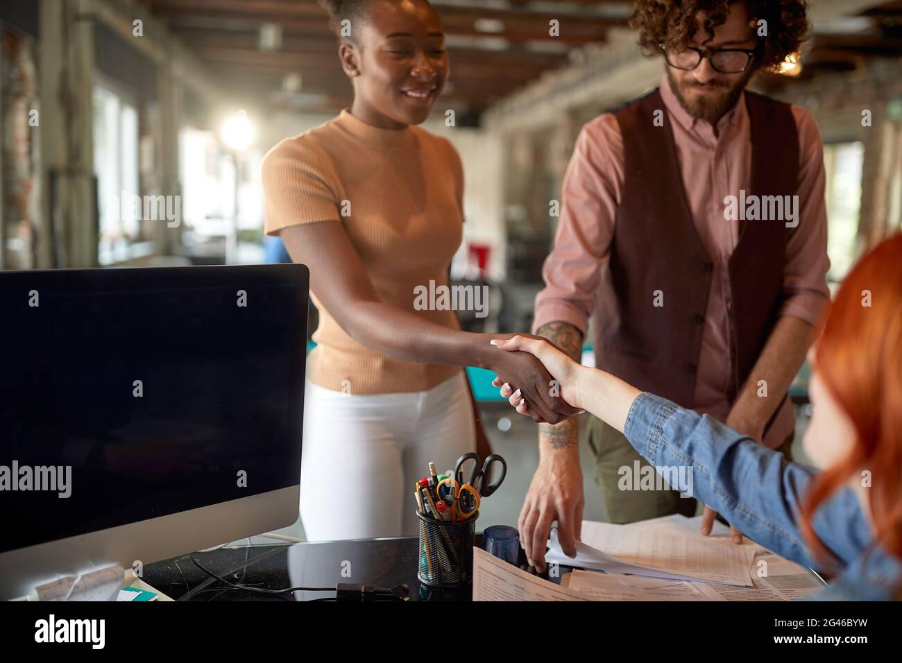 A young woman in a pleasant atmosphere in the office congratulate her ...