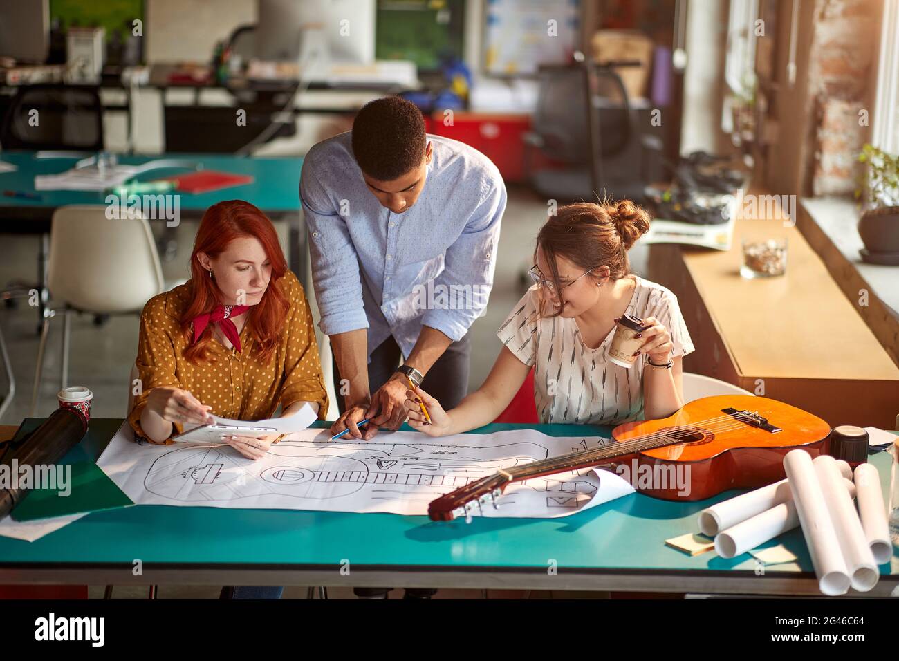 A group of young designers in a creative atmosphere in the office enjoy ...