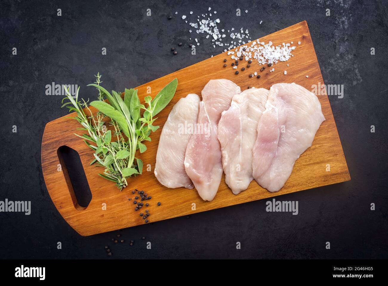 Raw traditional chicken escalope with tomatoes and herbs offered as top ...