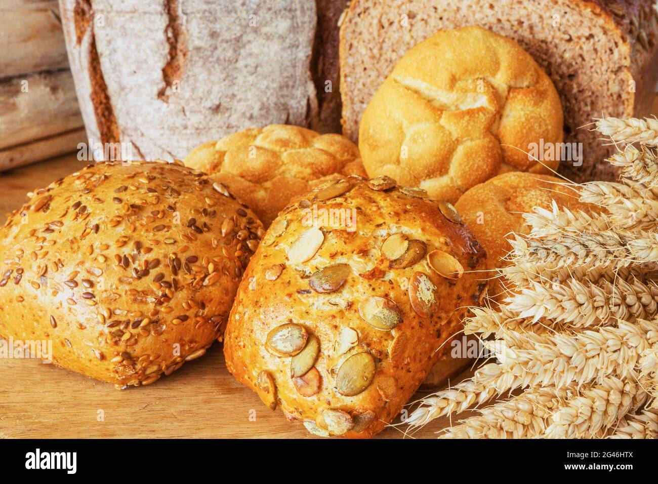 Assortment traditional breads and buns with a bundle of cereals wooden ...