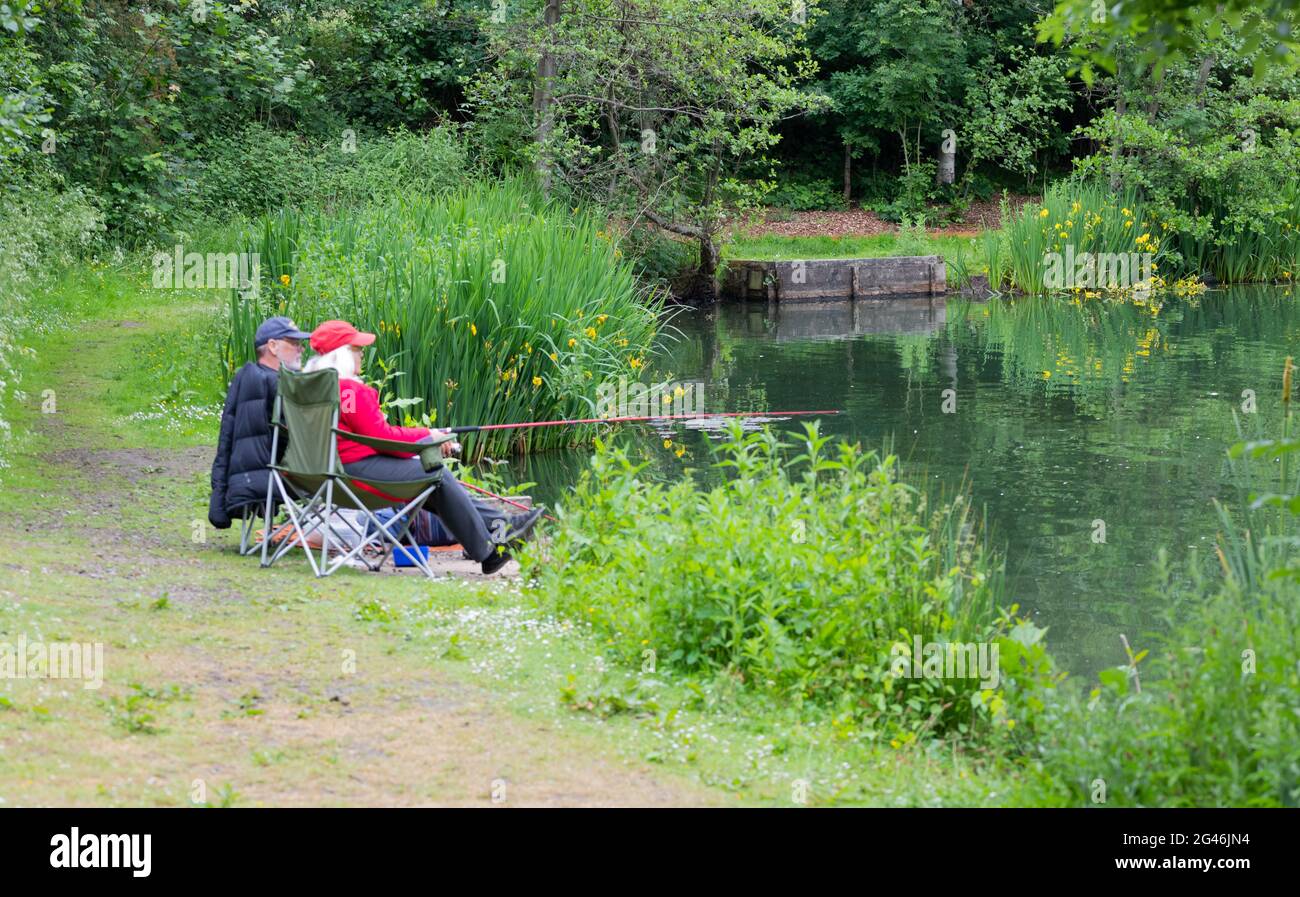 Chesterfield, UK. 19th June, 2021.Two People sitting fishing in Kenning ...