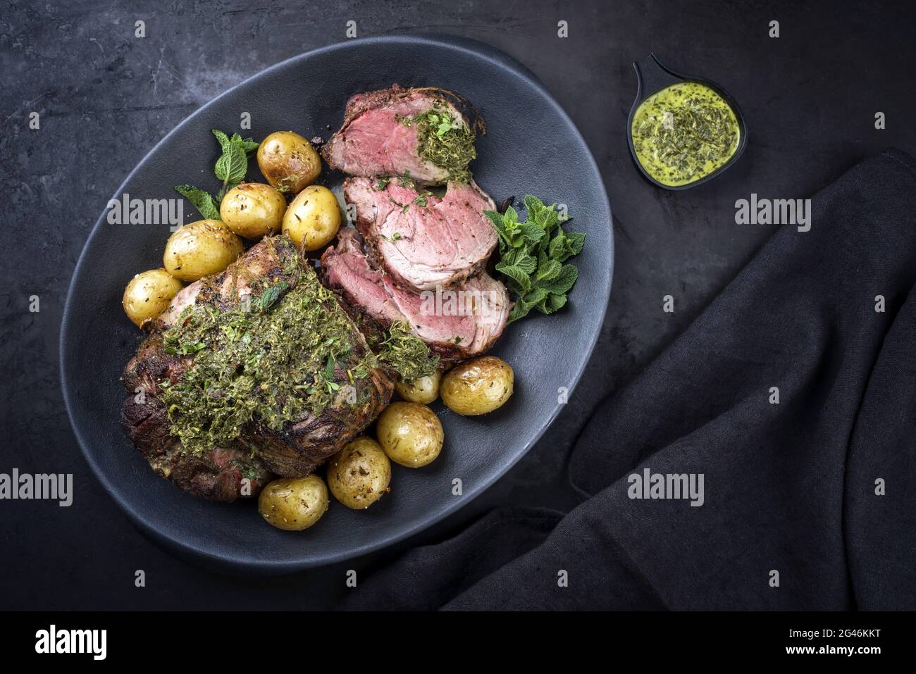 Traditional English barbecue lamb roast sliced with mint sauce and ...
