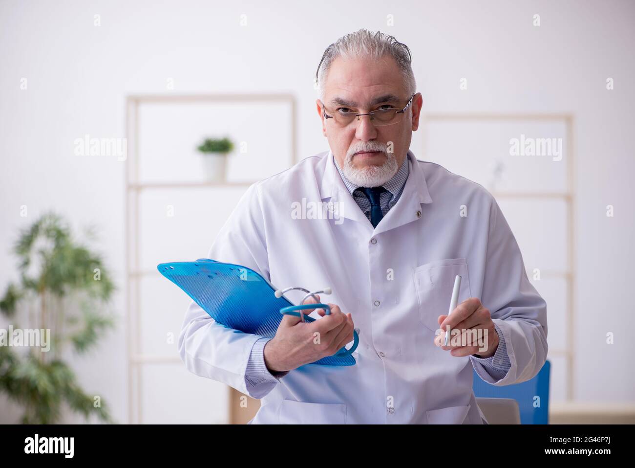 Old doctor working in the clinic Stock Photo - Alamy