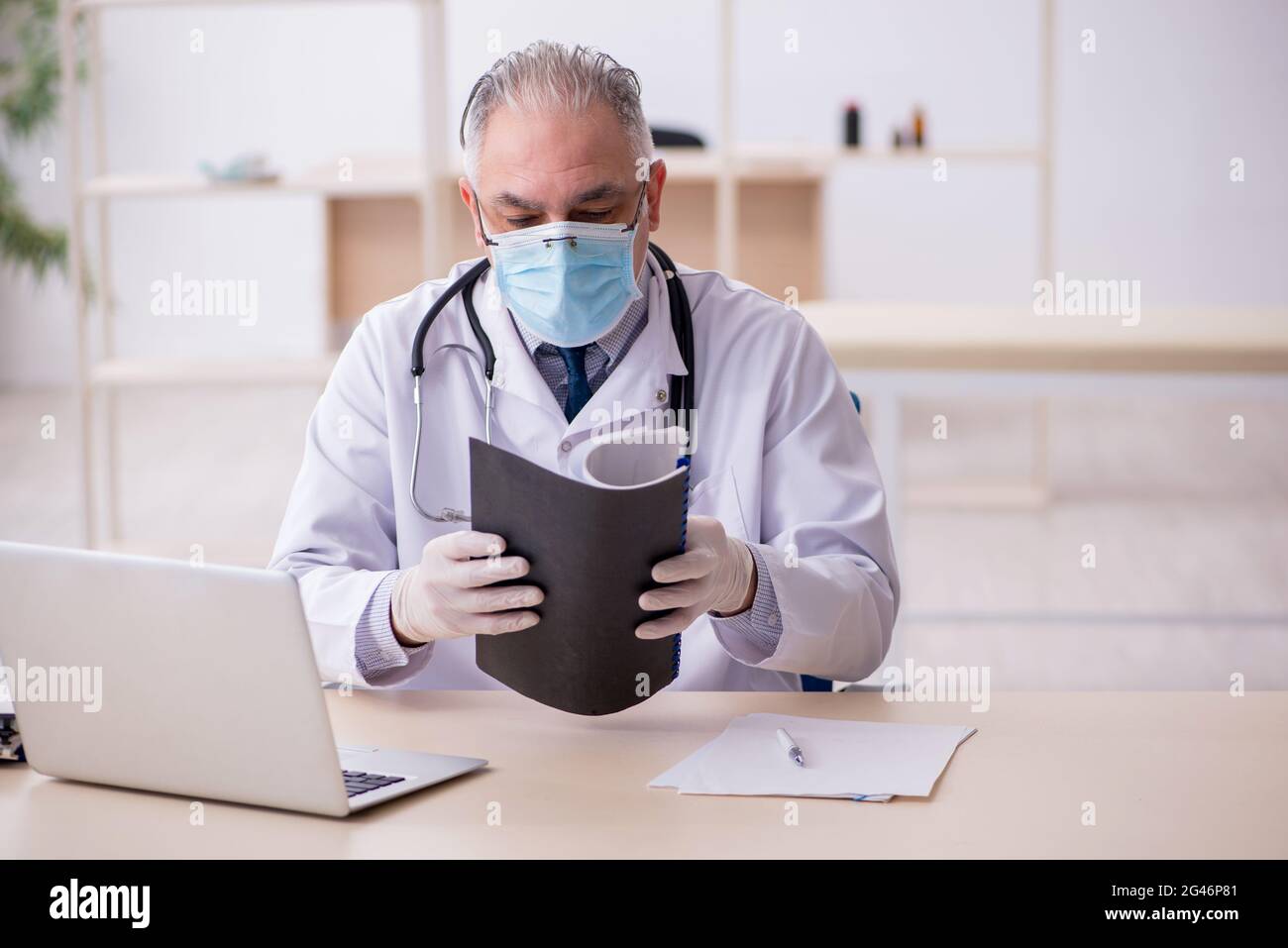 Old doctor working in the clinic Stock Photo - Alamy