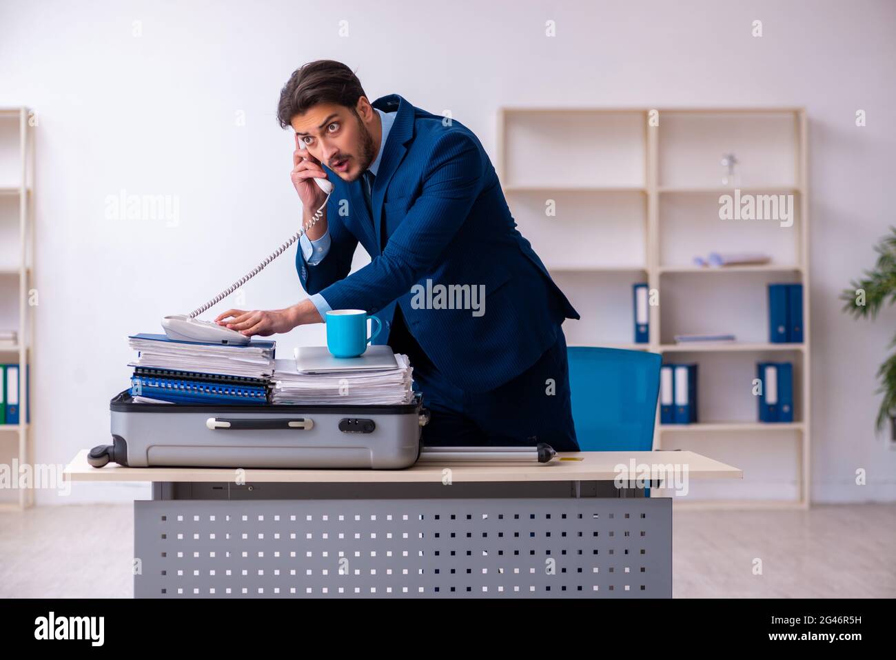 Young businessman employee preparing for business trip at workplace ...