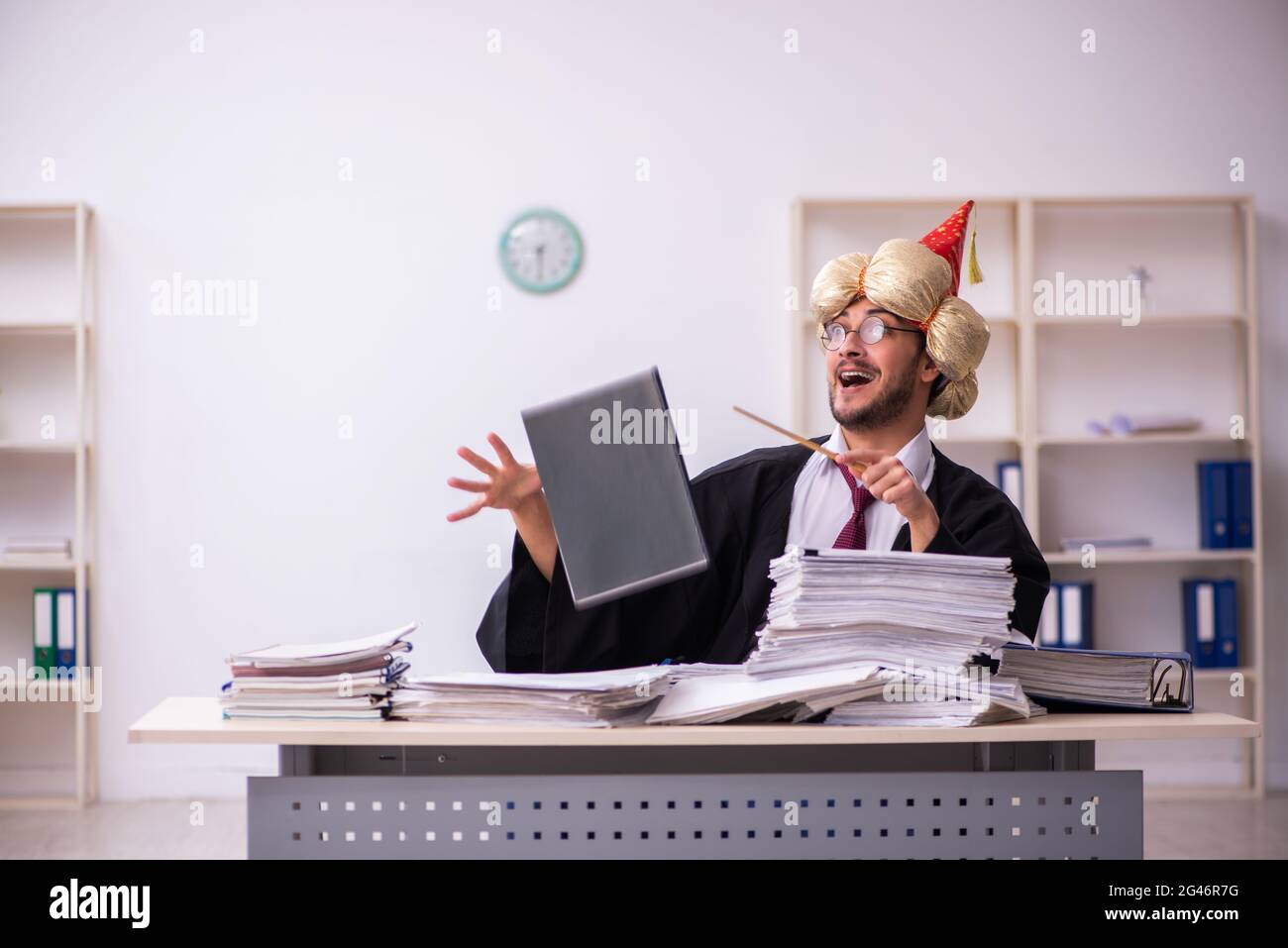 Funny young employee magician and too much work in the office Stock ...