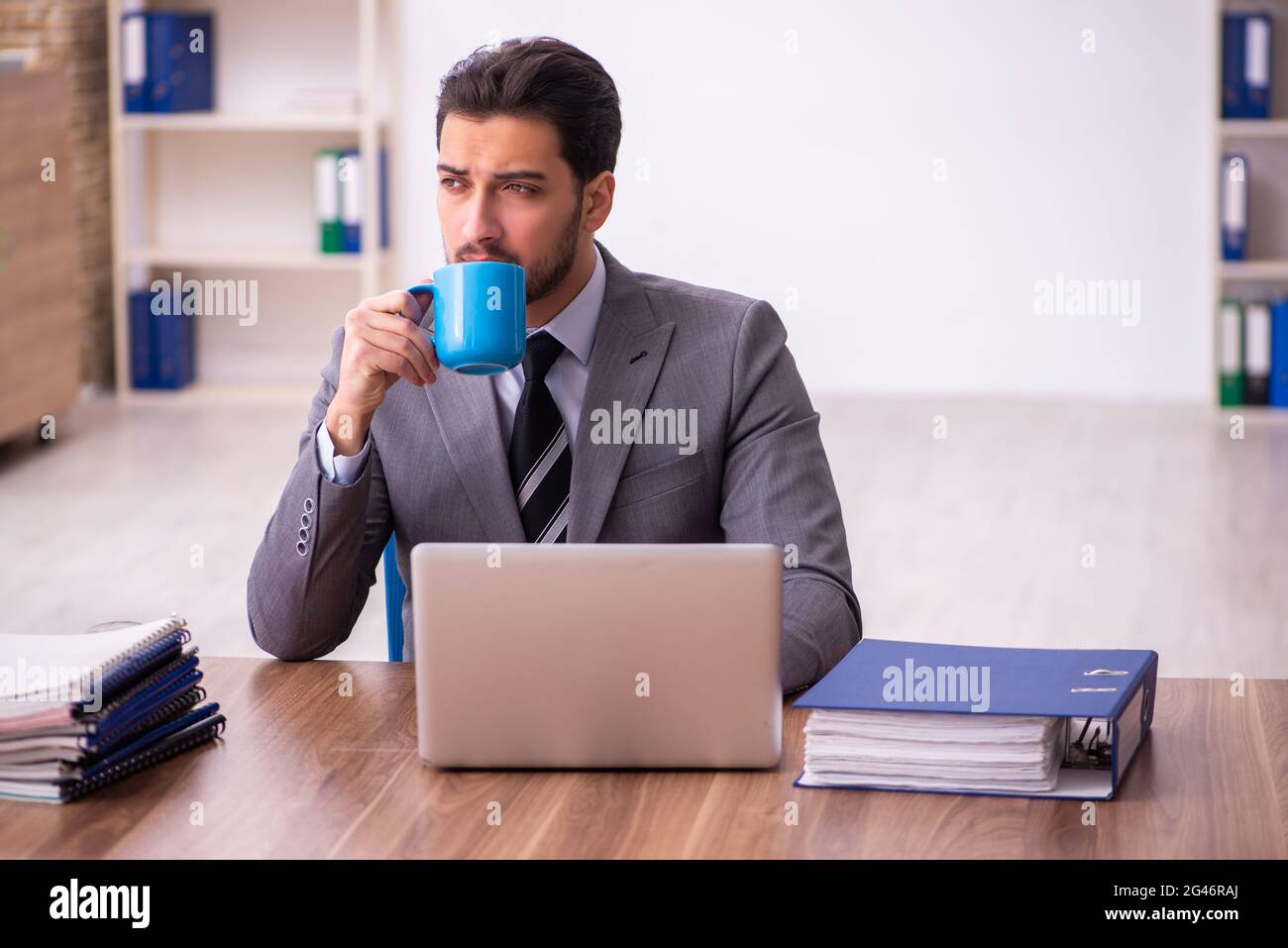 Young male employee having break at workplace Stock Photo - Alamy