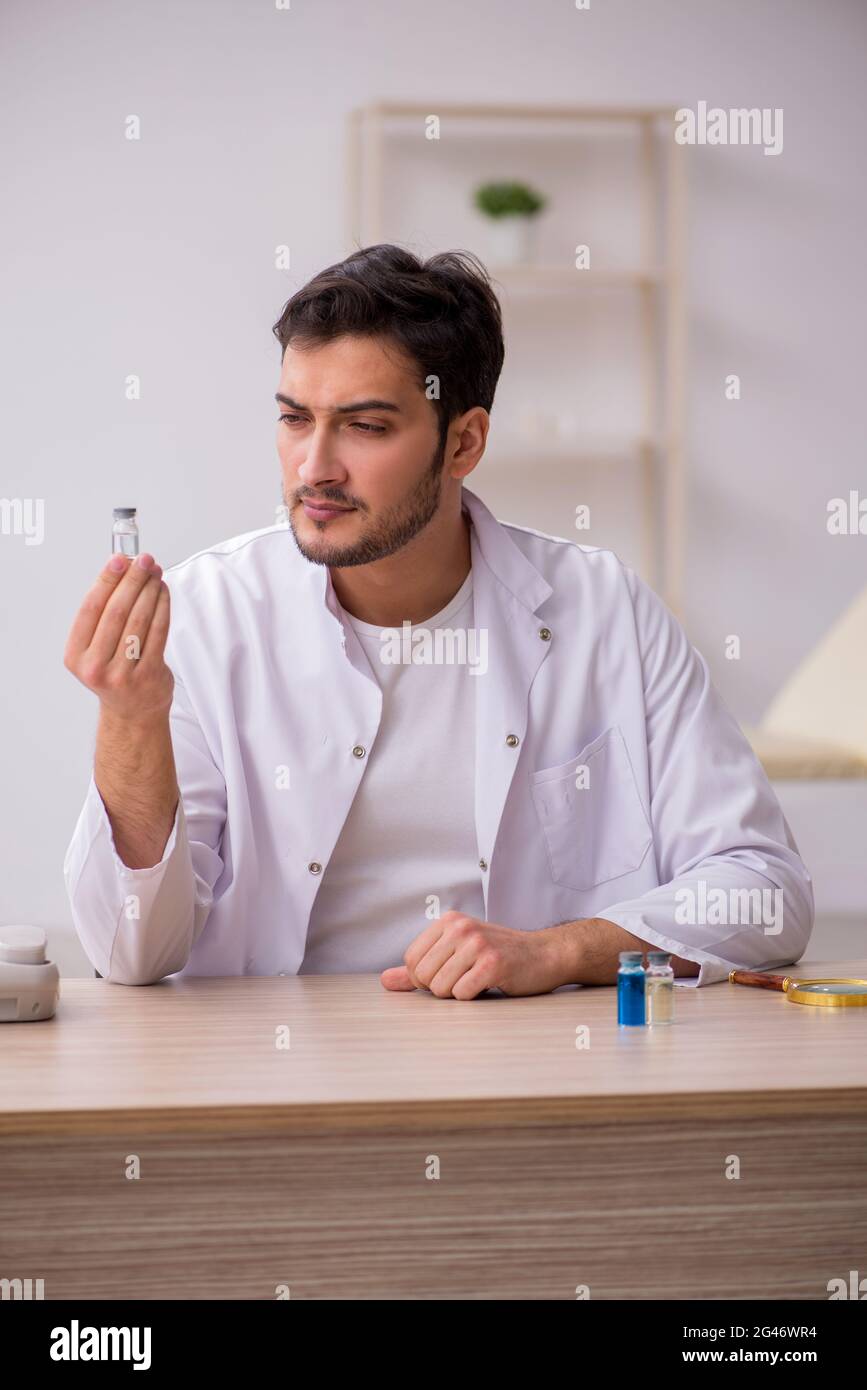 Young male chemist doctor holding vial at the lab Stock Photo - Alamy