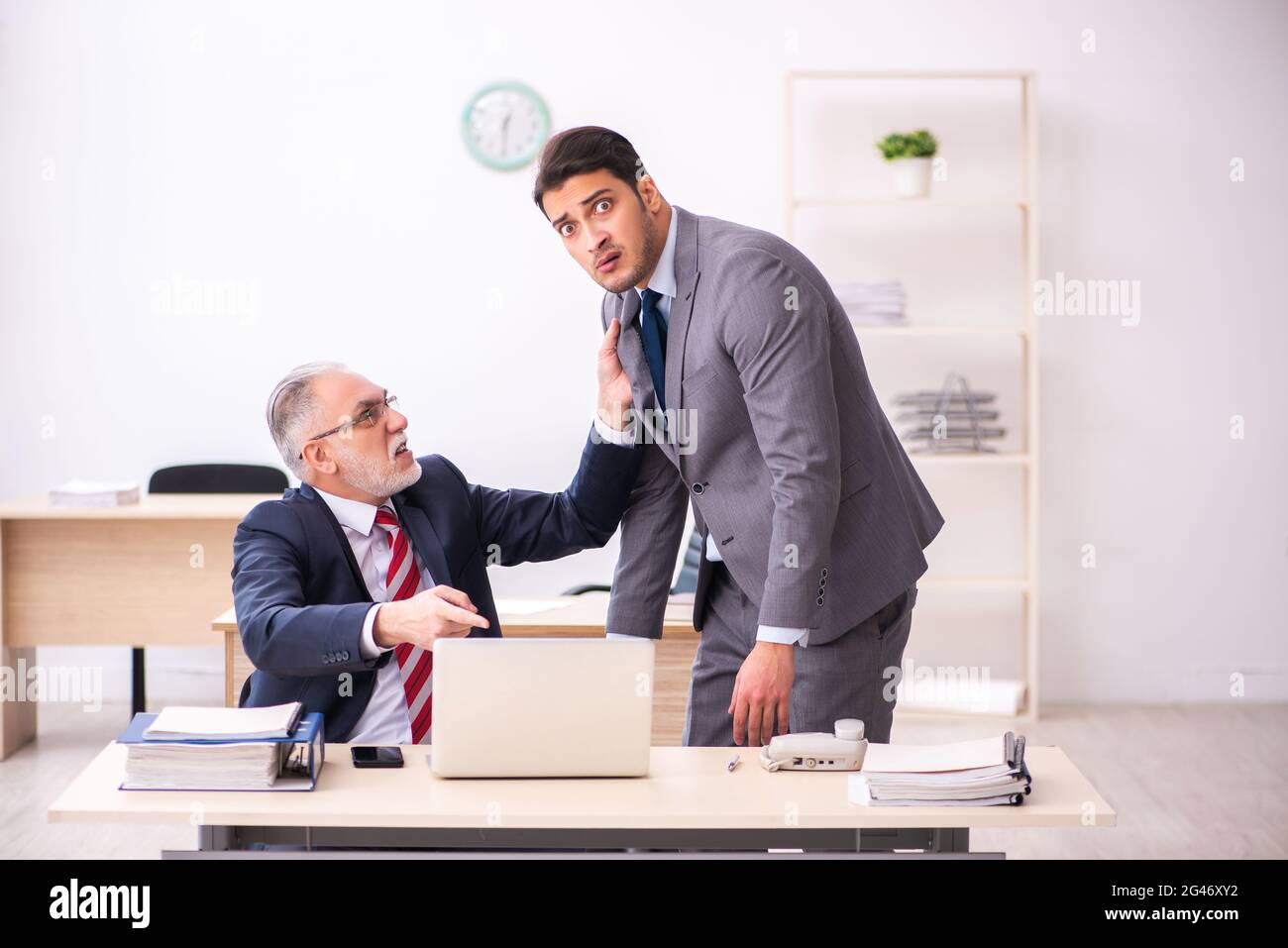 Old boss and young employee working at workplace Stock Photo - Alamy