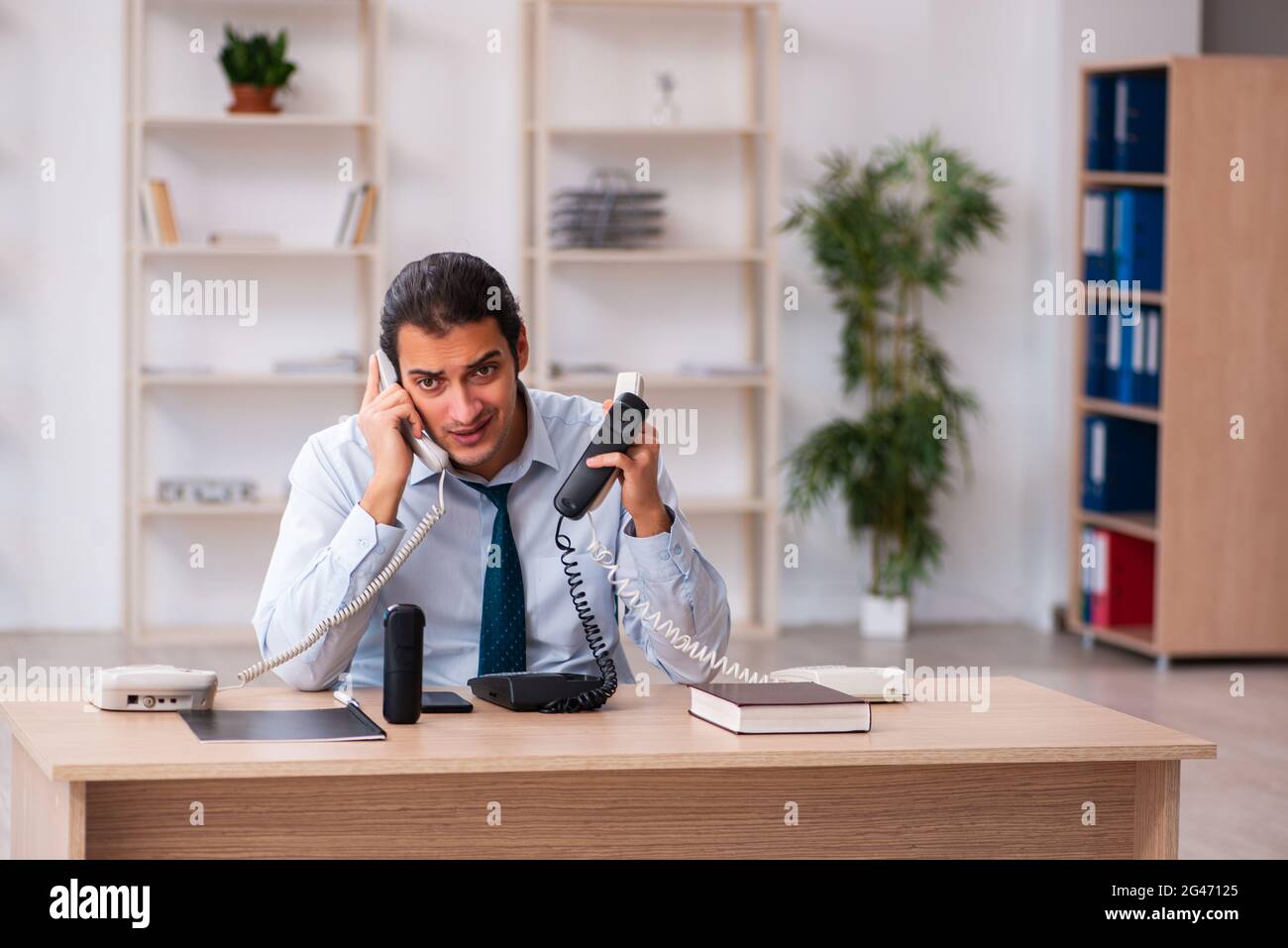 Young call center operator working at his desk Stock Photo - Alamy