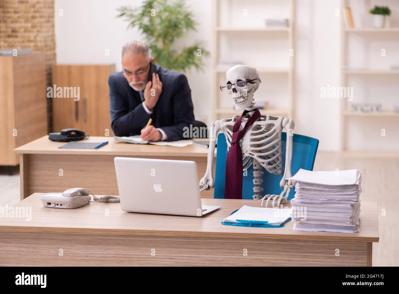 Dead employee working in the office in funny concept Stock Photo - Alamy