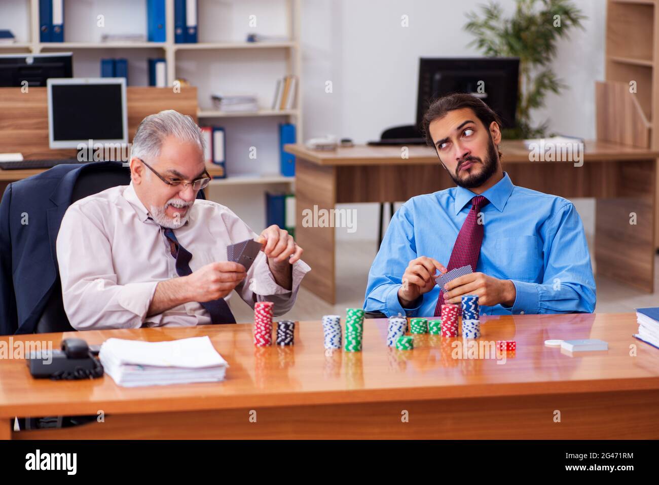 Two employees playing cards at workplace Stock Photo - Alamy