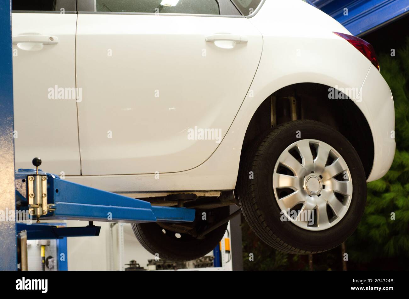 Back view of a white car on a hydraulic vehicle ramp lift Stock Photo ...