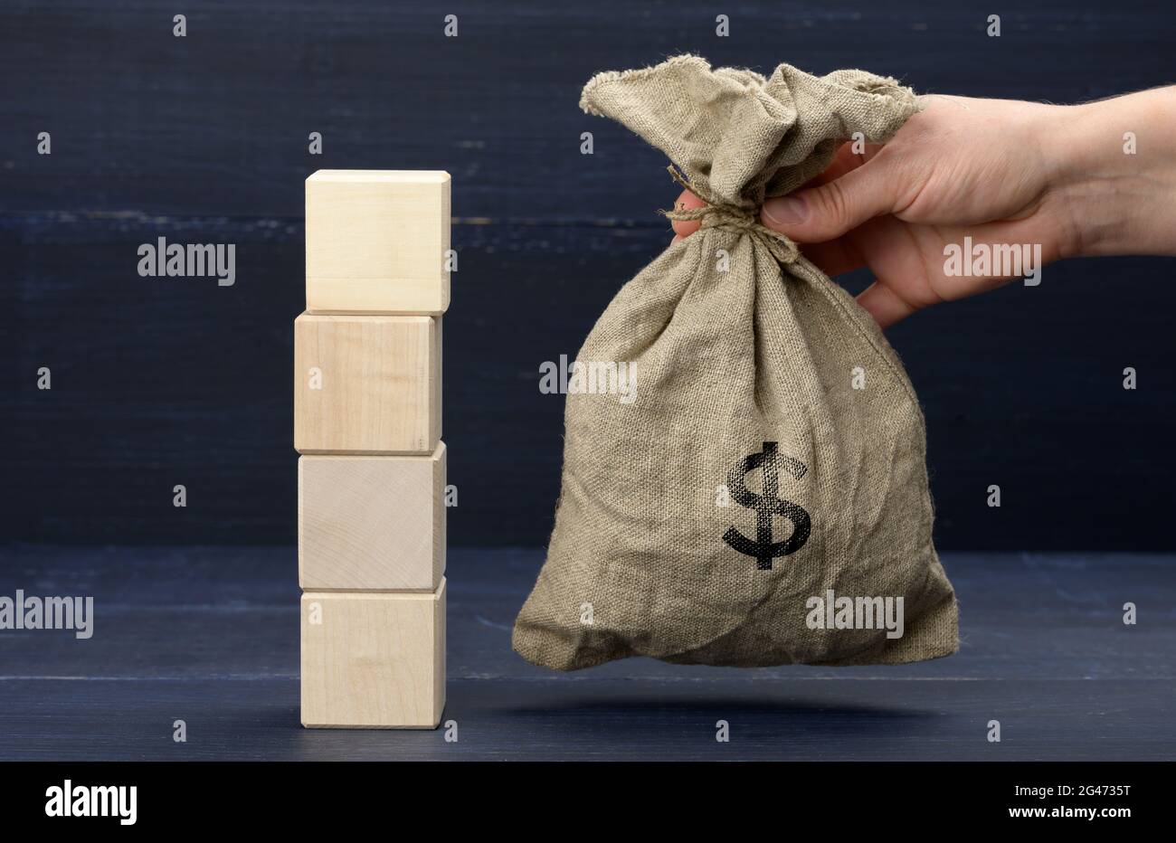 A stack of wooden cubes and a woman's hand holds a full bag with a ...